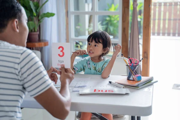parent showing number on a flash card during studying - Stock Image ...