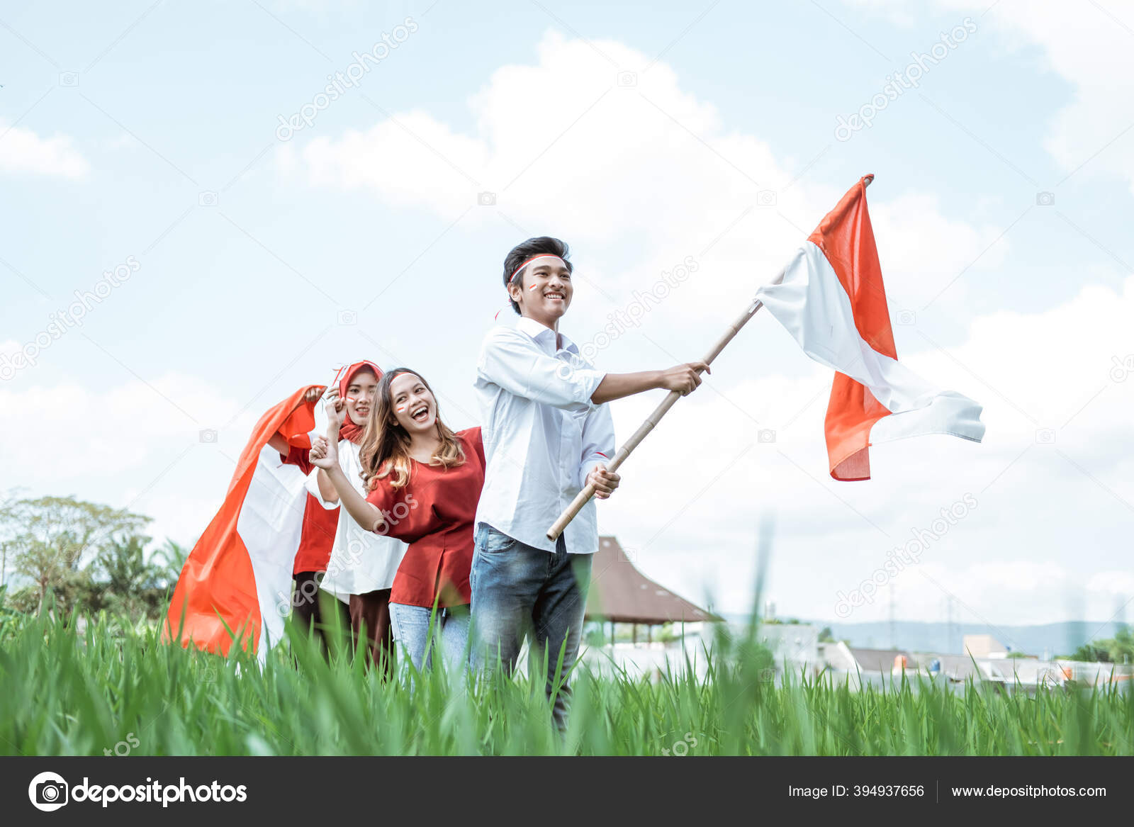 Asian man holds and raises Indonesian flag while following behind his ...