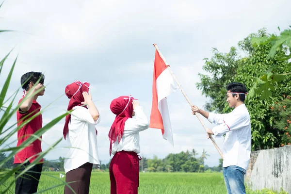 Asian young man in white walking carrying an Indonesian flag and his ...