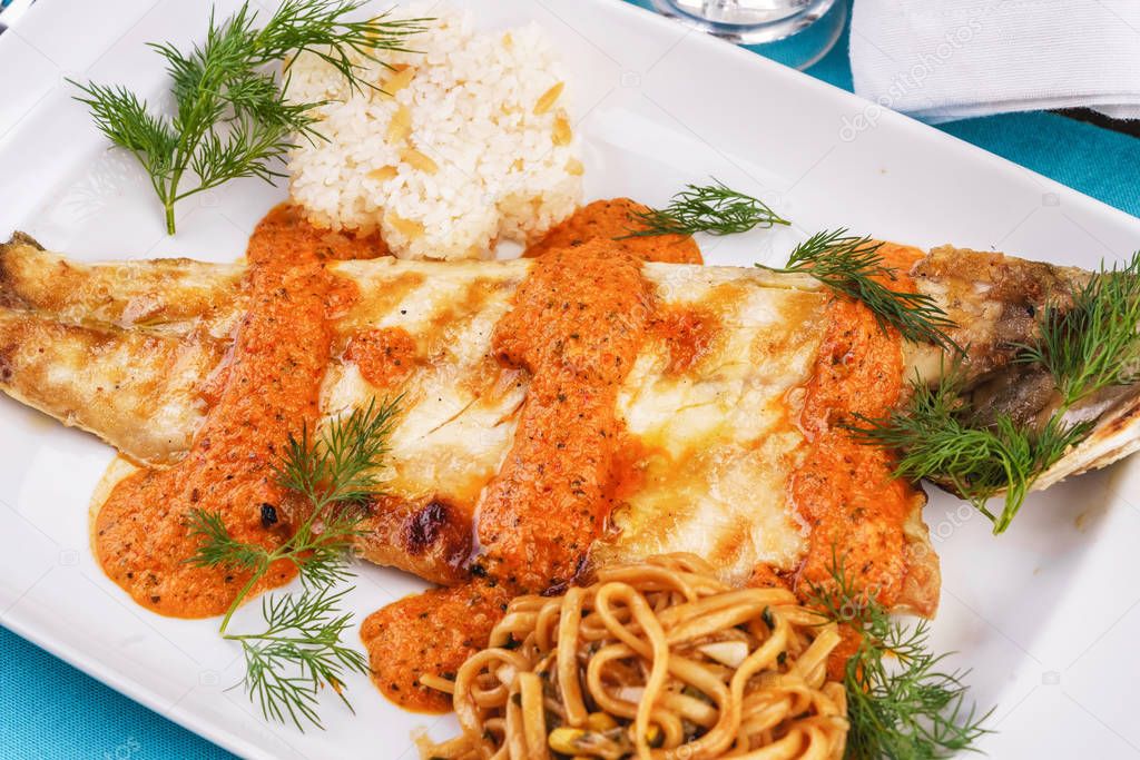 Pescado al horno en masa con salsa de caviar, servido con fideos en ...