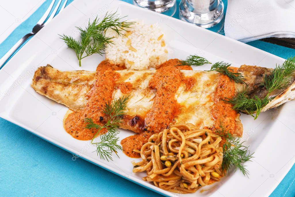 Pescado al horno en masa con salsa de caviar, servido con fideos en ...