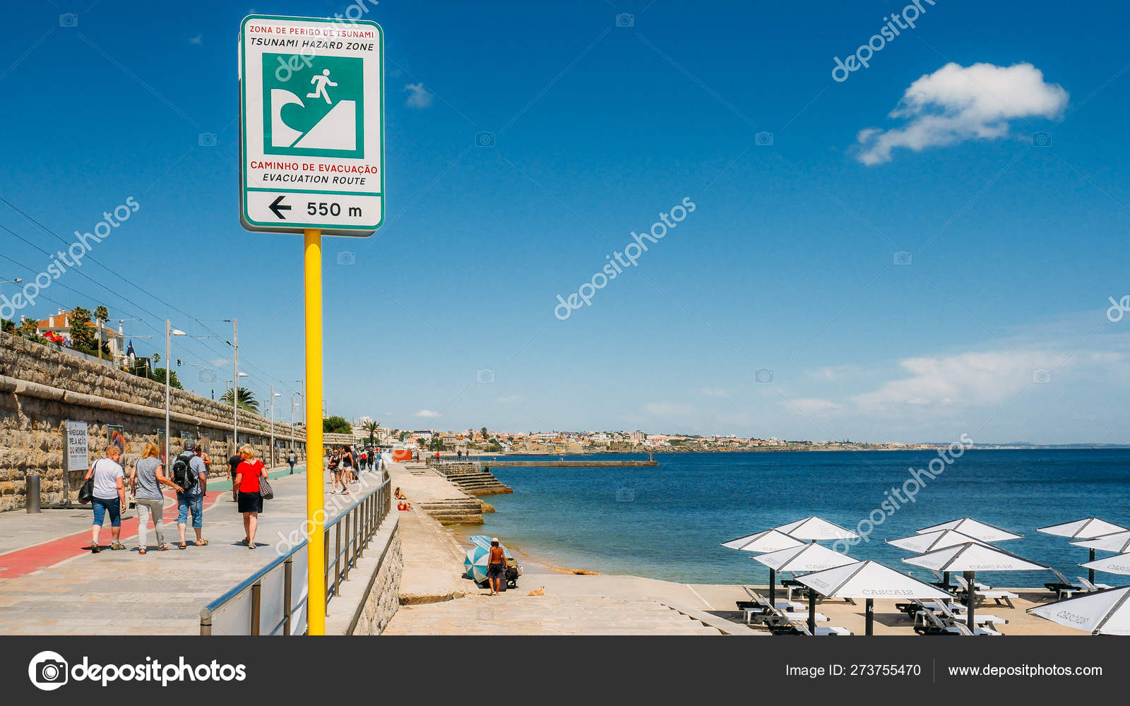 Tsunami evaculation route sign next to a seaside promenade with ...