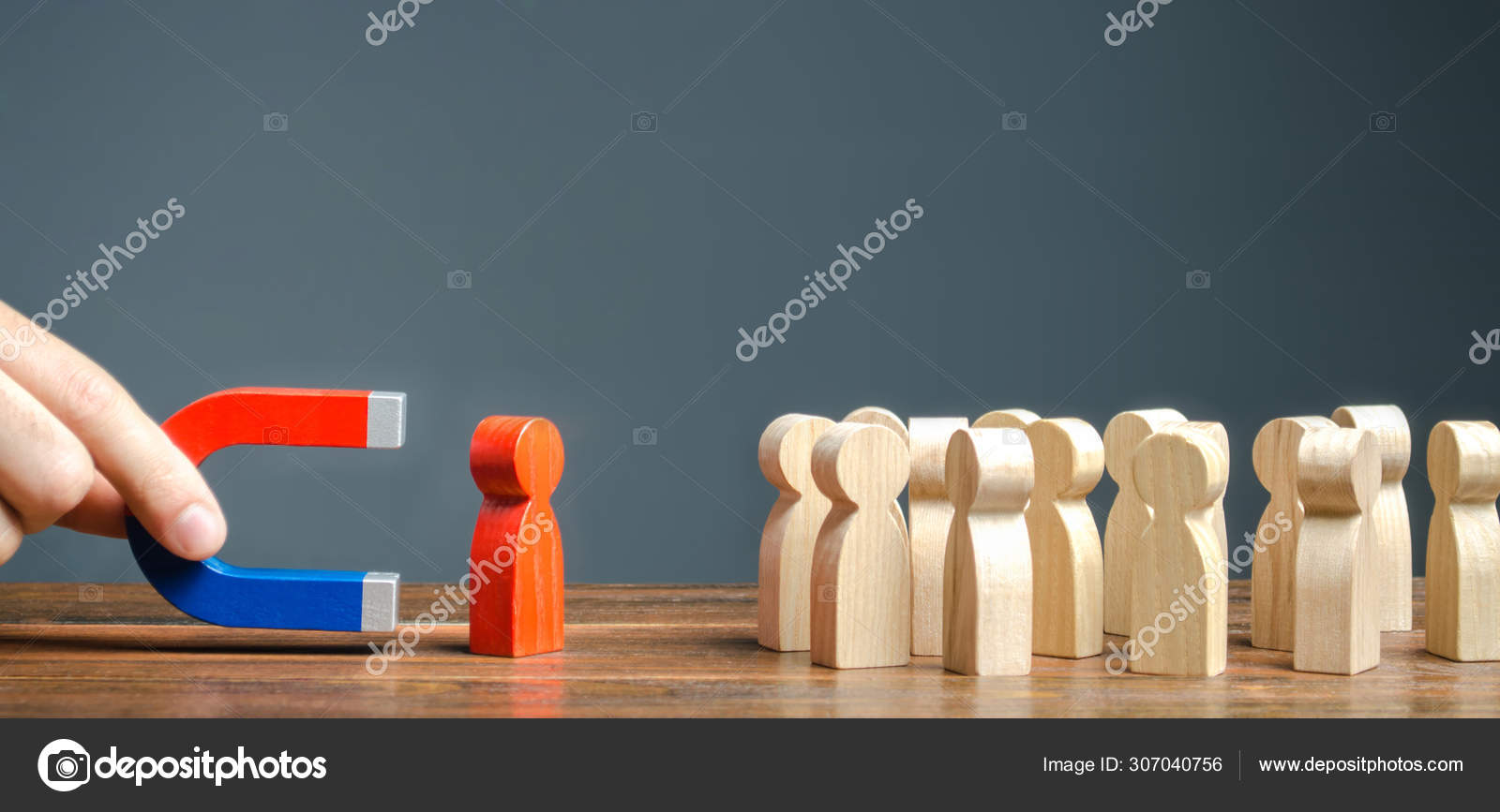 Una mano con un imán azul rojo saca una figura humana roja de la ...