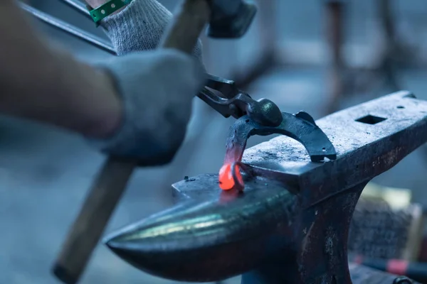 The smith behind work. In hands at the smith nippers which he holds the ...
