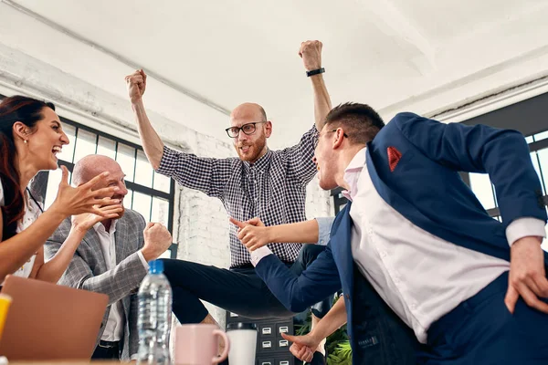 Excited diverse business team employees screaming celebrating good news ...