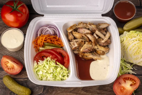 Fast food in lunch box - fresh vegetables, pita bread and chicken ...