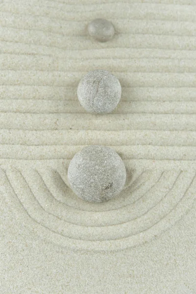 Zen garden. Pyramids of white and gray zen stones on the white sand ...