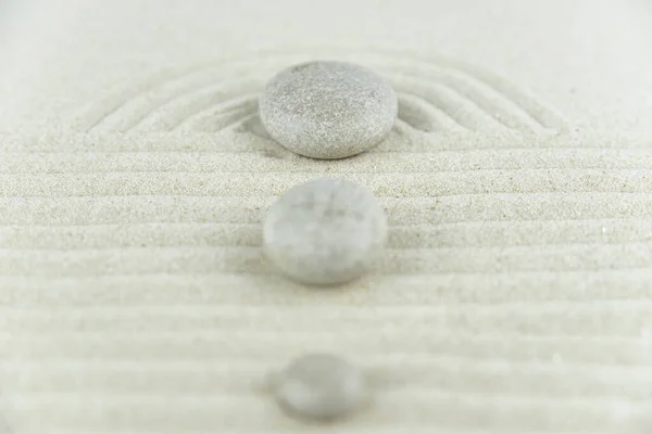 Zen garden. Pyramids of white and gray zen stones on the white sand ...
