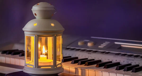 Keys for piano with light of a lantern with a candle in the evening ...
