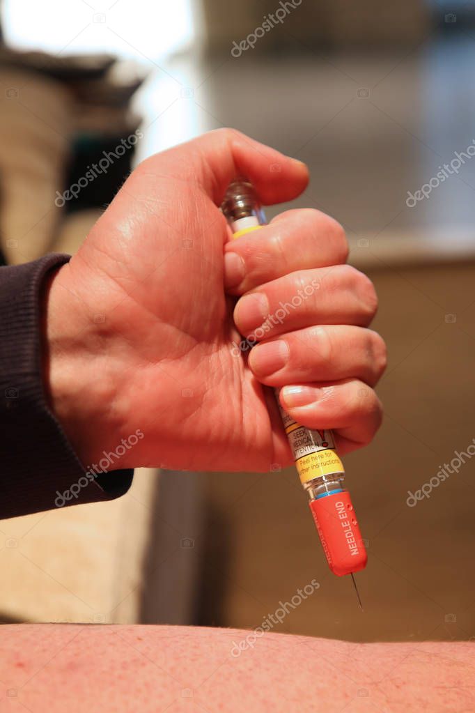 Inyectando medicina de emergencia. Epinephrine Auto inyectable es un dispositivo médico para ...