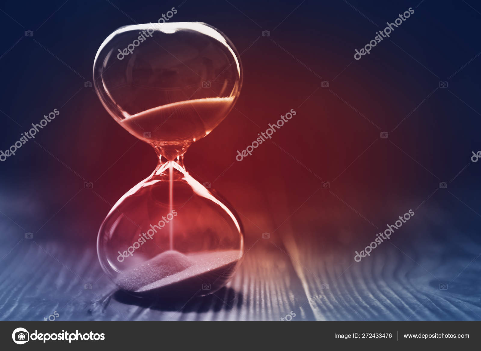 Modern Hourglass with dark background, sand trickling through the bulbs ...