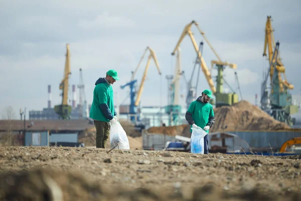 Two workers of environmental protection organization cleaning territory ...