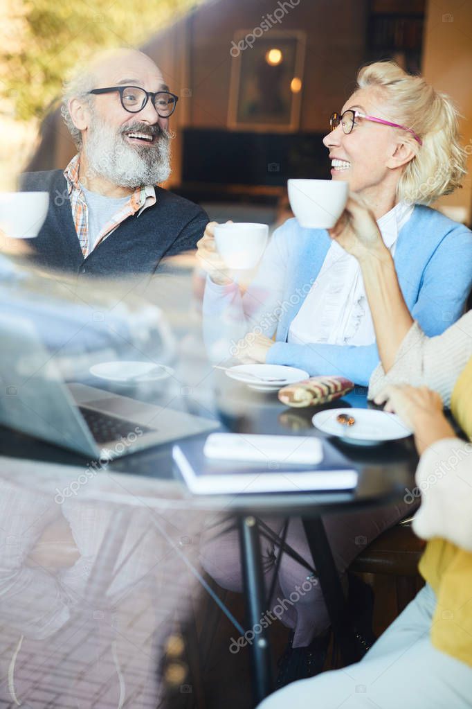 Grupo de personas mayores alegres tomando té y discutiendo noticias ...