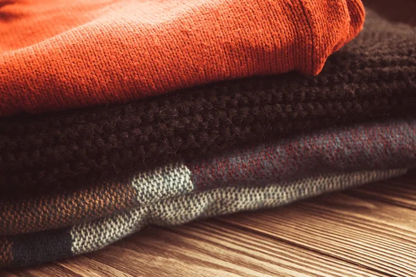 folded woolen things on wooden background insulate, vintage image ...