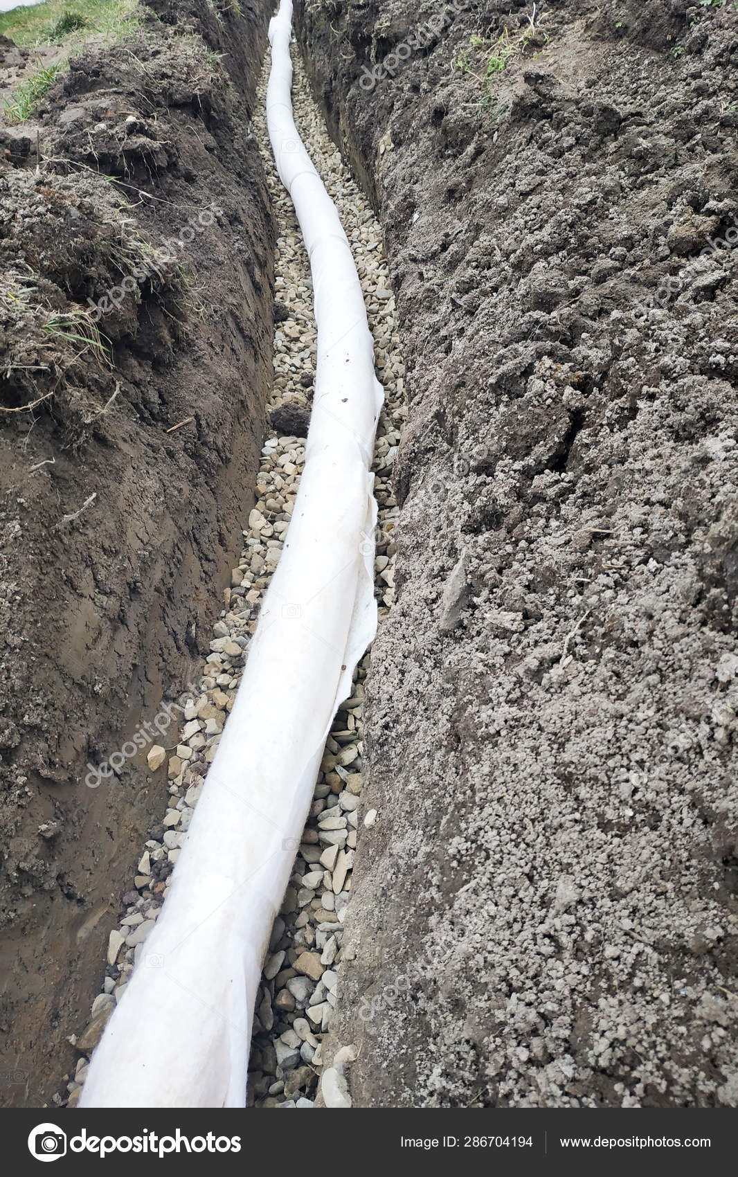 Workers carry out drainage works to drain the water around the house ...