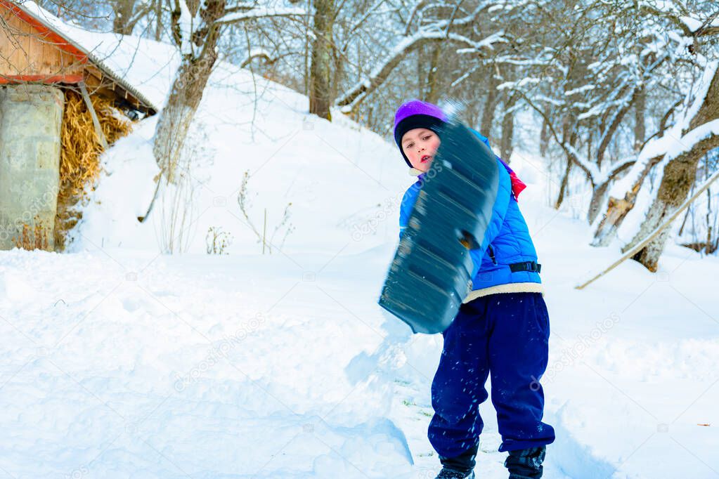 Despu s de mucha nieve, el ni o despeja la nieve con una pala. 2024