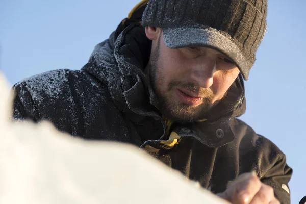 Portrait of an assembler worker in a cap with a black visor in an ice ...