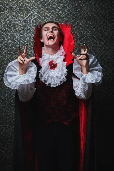 A bloodthirsty vampire aristocrat scares his victim by Baring his teeth ...