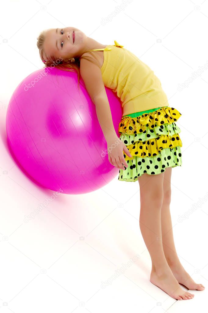 niña haciendo ejercicios en una pelota grande para la aptitud. 2022
