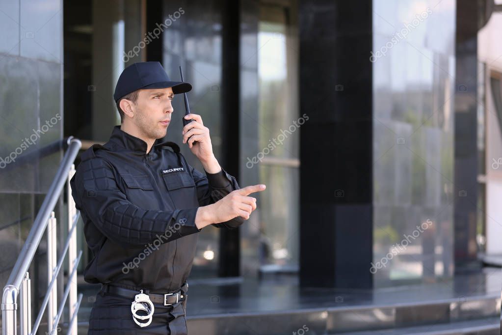 Guardia de seguridad masculino usando transmisor de radio portátil al ...