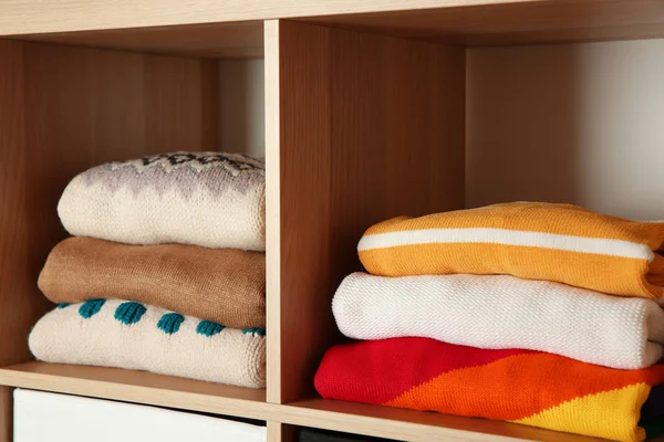Stacks of folded winter clothes on shelves in wardrobe - Stock Image ...