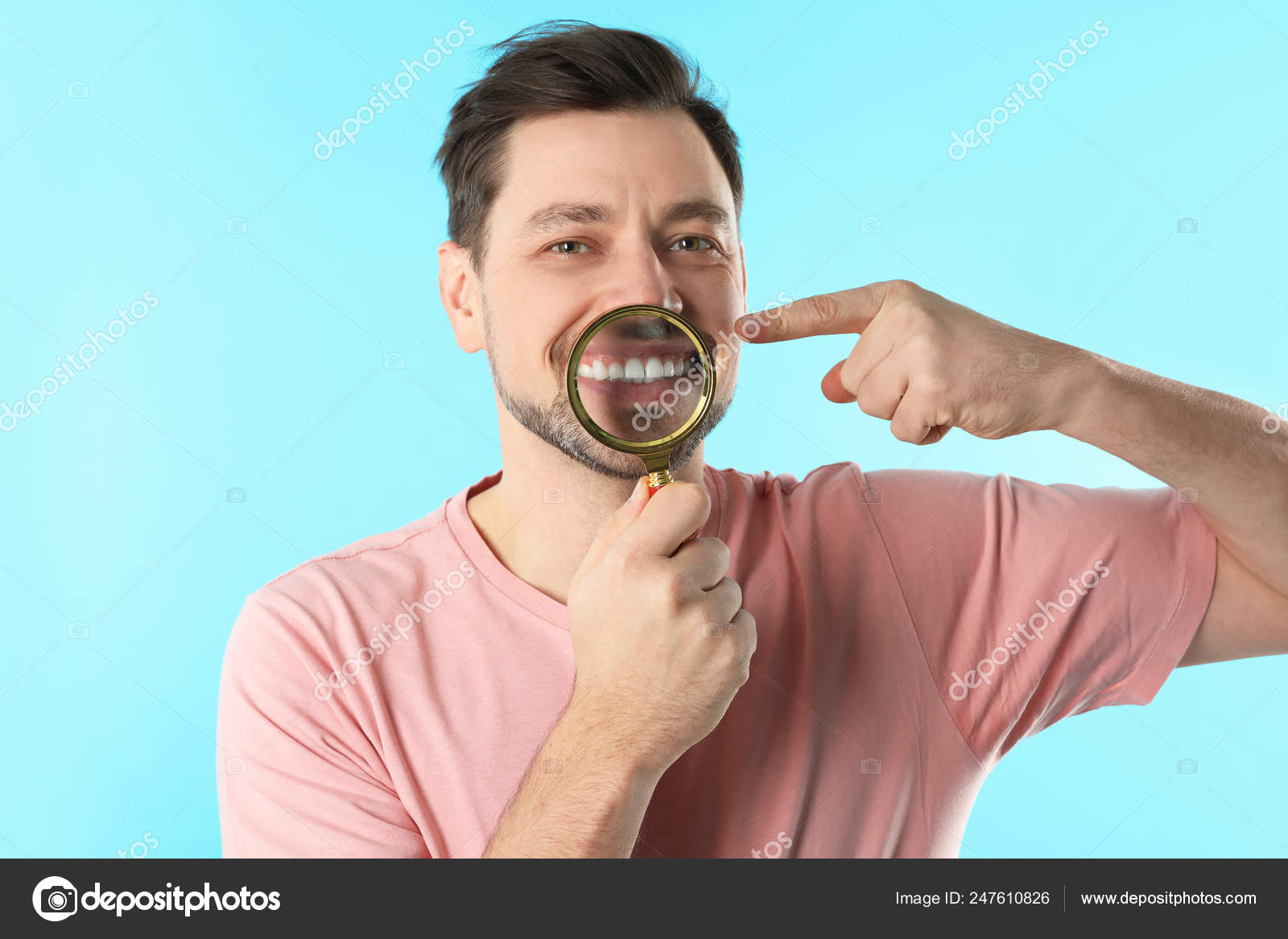 Smiling man with perfect teeth and magnifier on color background Stock ...