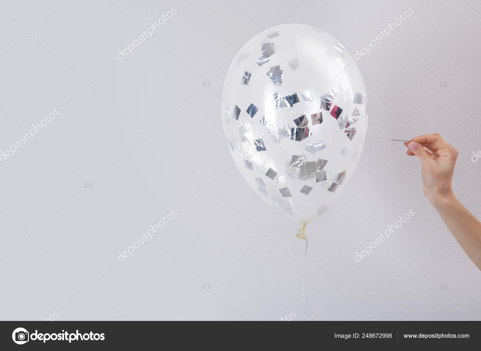 Woman piercing balloon with needle on white background, closeup Stock ...