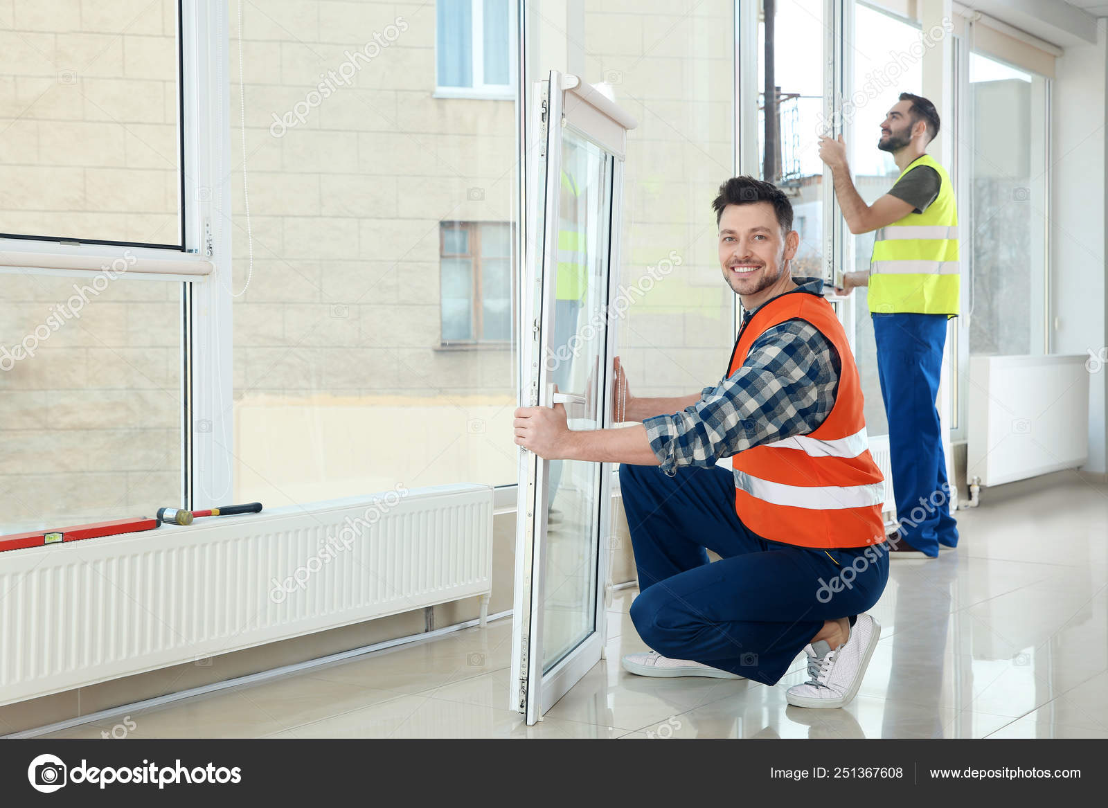 Construction workers installing plastic windows in house Stock Photo by ...
