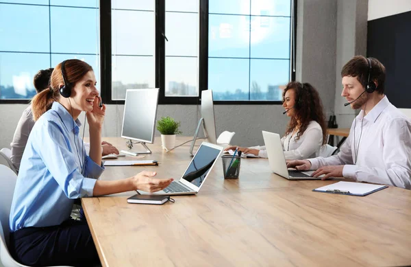 Team of technical support with headsets at workplace - Stock Image ...