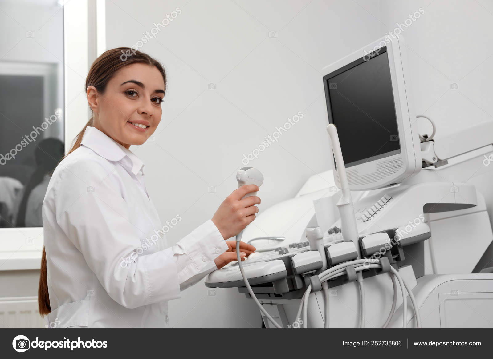 Professional sonographer using modern ultrasound machine in clinic ...