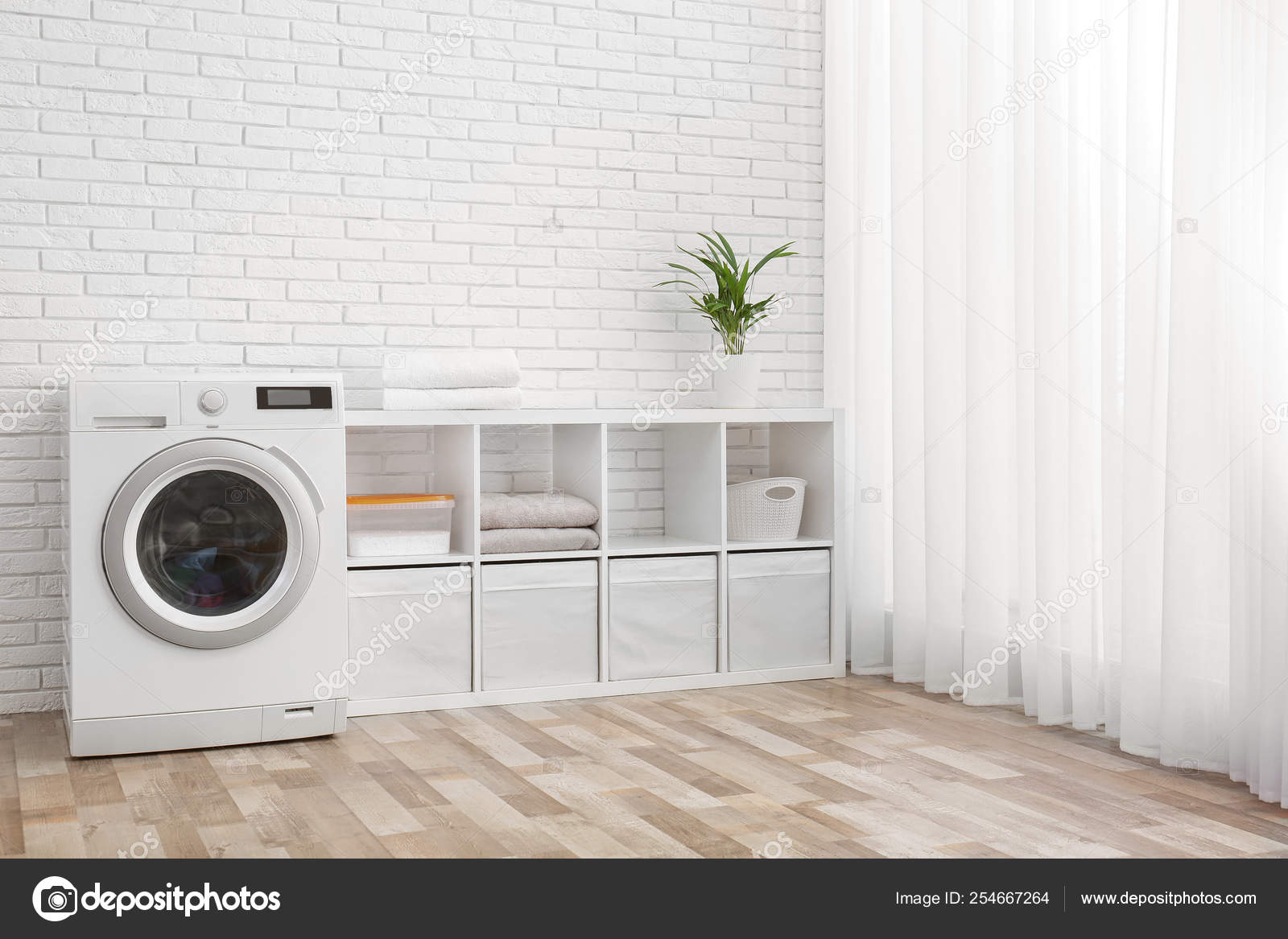 Modern washing machine near brick wall in laundry room interior, space ...