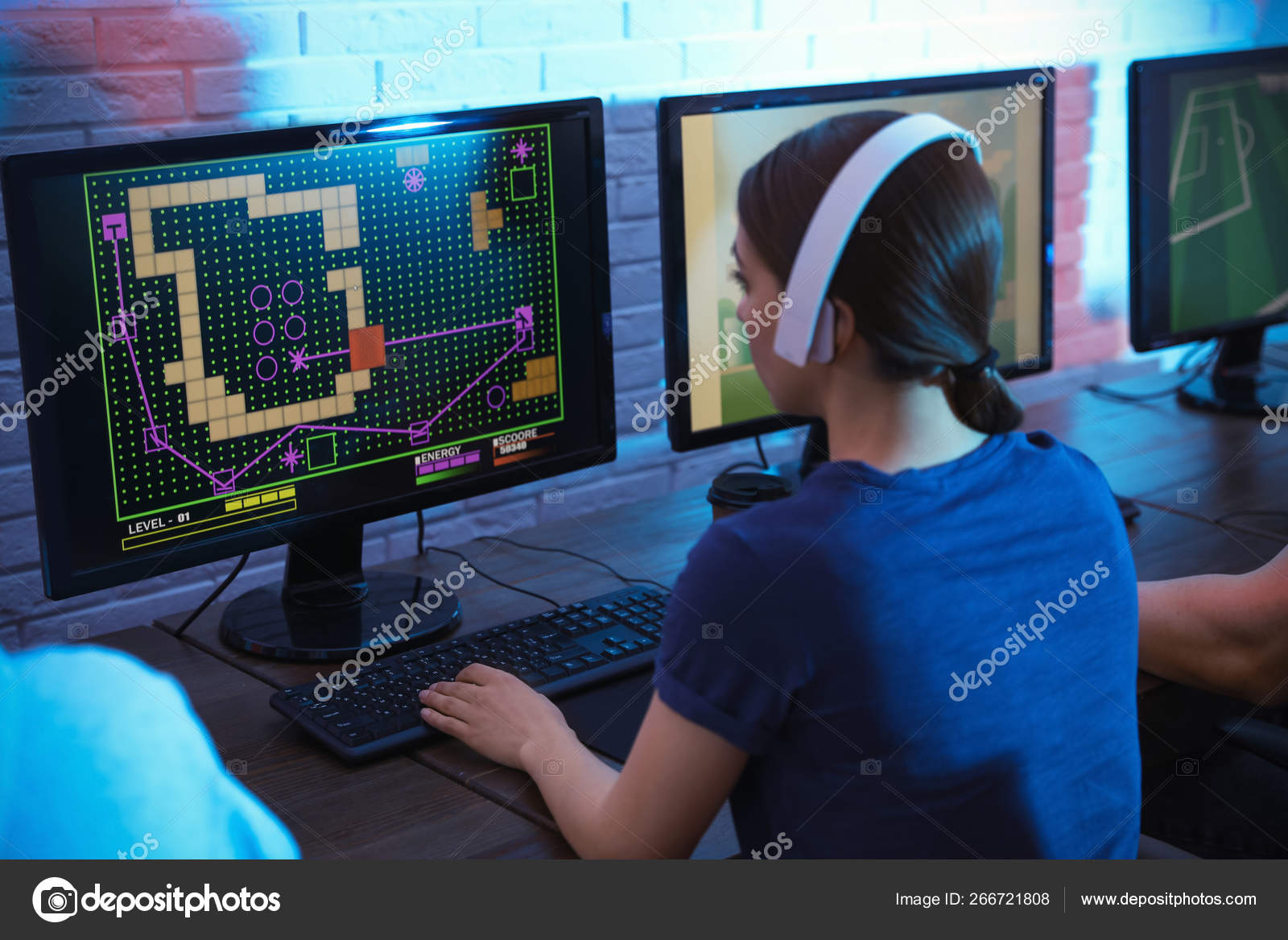 Young people playing video games on computers indoors. Esports ...