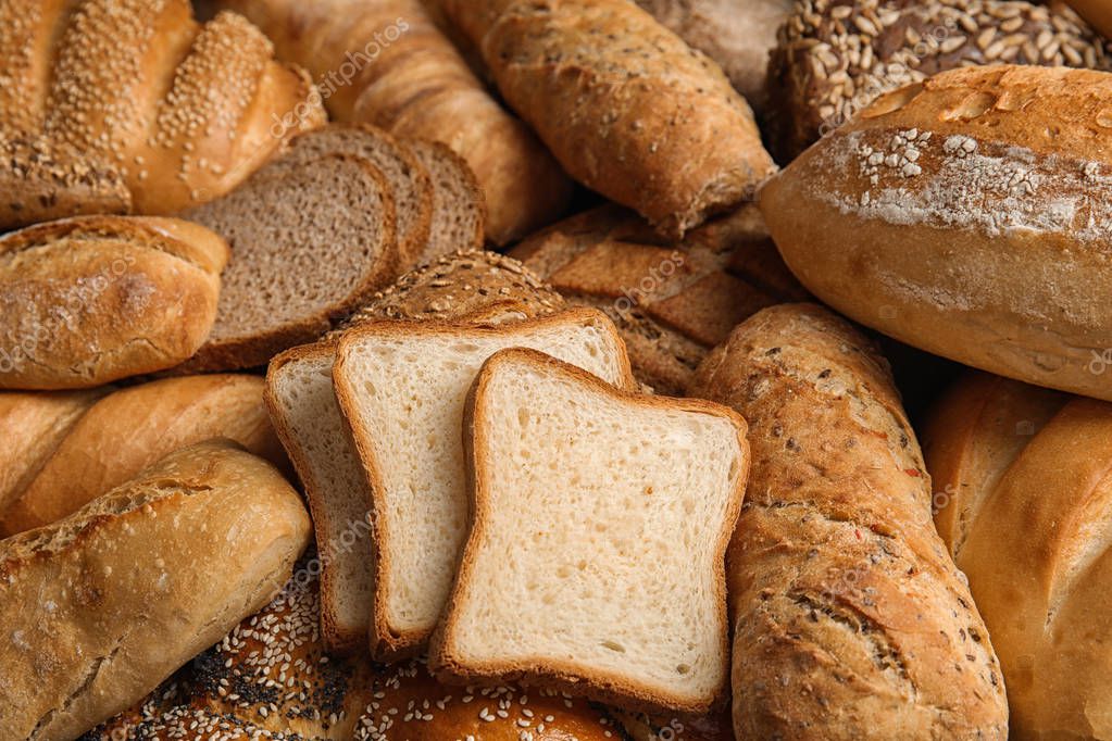 Diferentes tipos de pan fresco como fondo, primer plano 2024