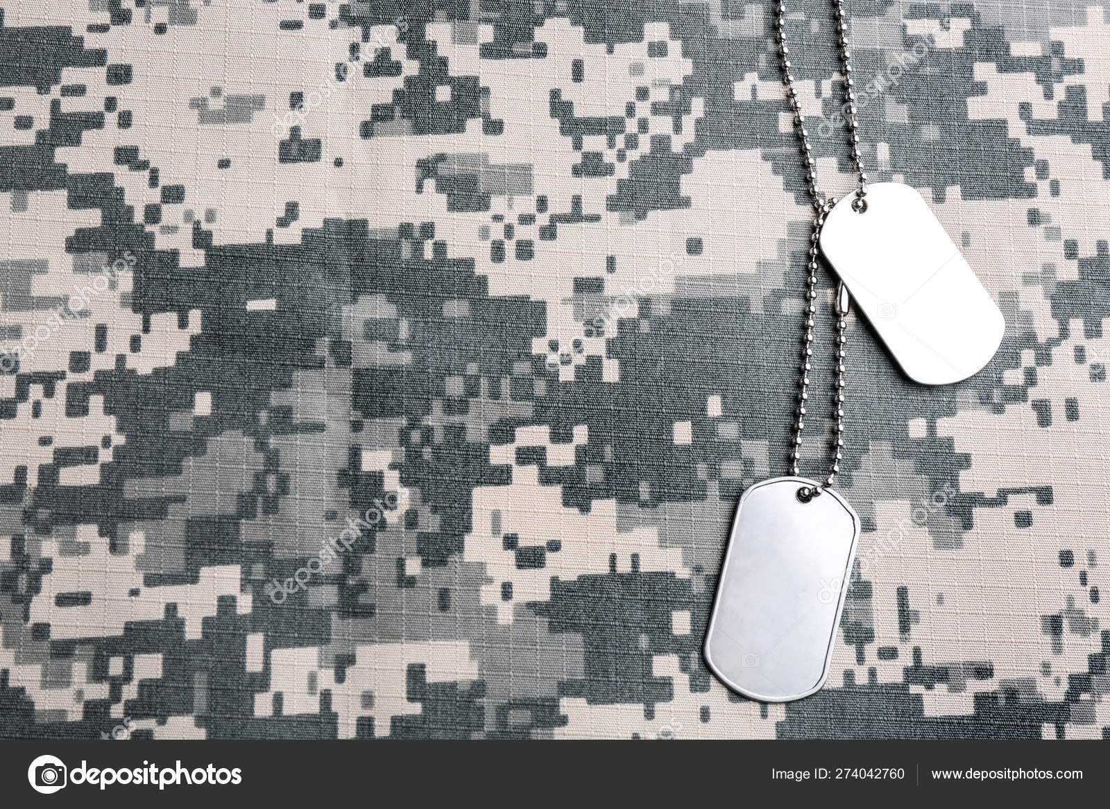Military ID tags on camouflage background, top view. Space for text ...