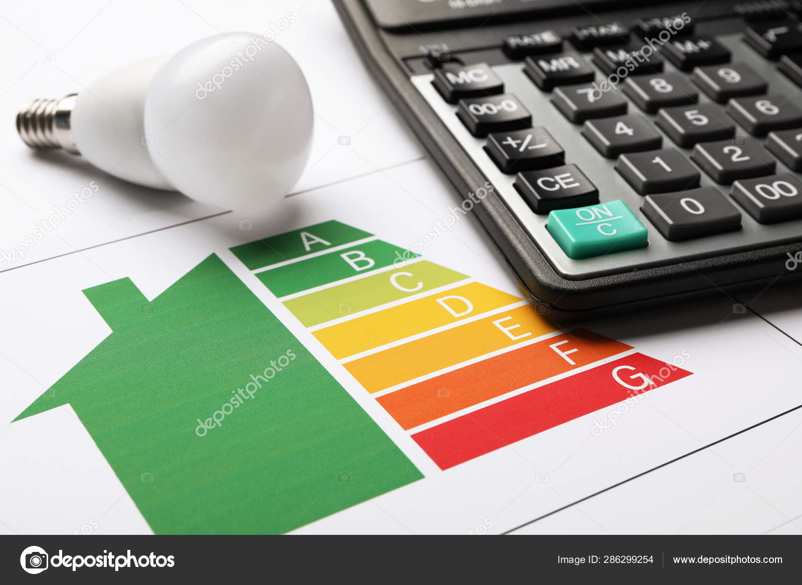 Energy efficiency rating chart, LED light bulb and calculator on white ...