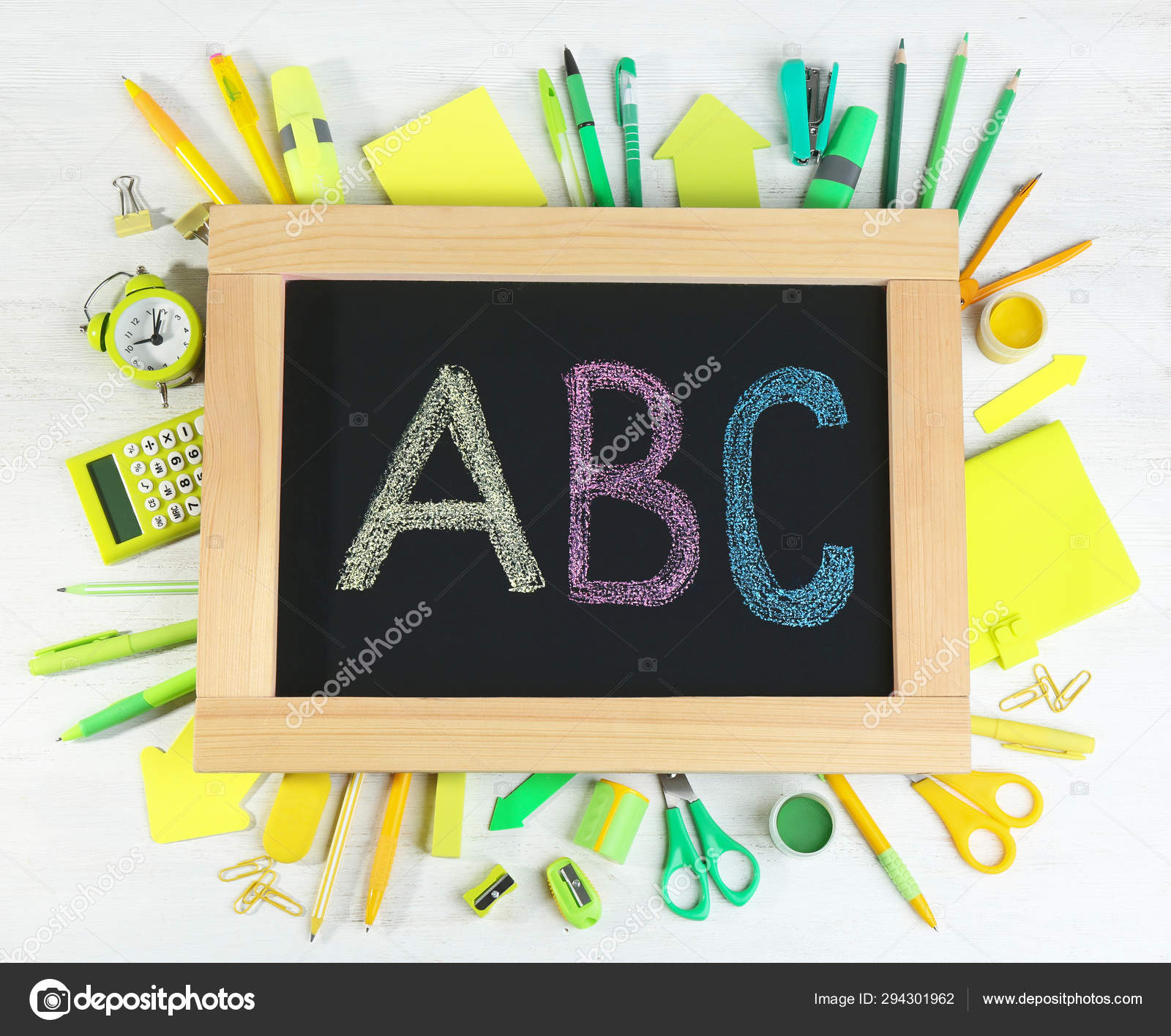 Small chalkboard with letters ABC and different school stationery on ...