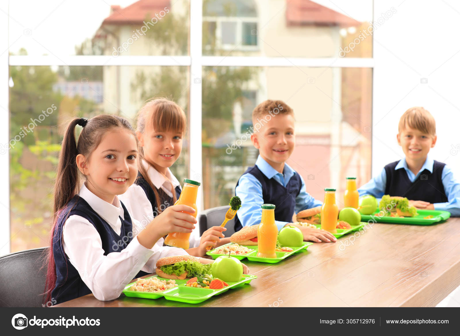 Happy children at table with healthy food in school canteen Stock Photo ...