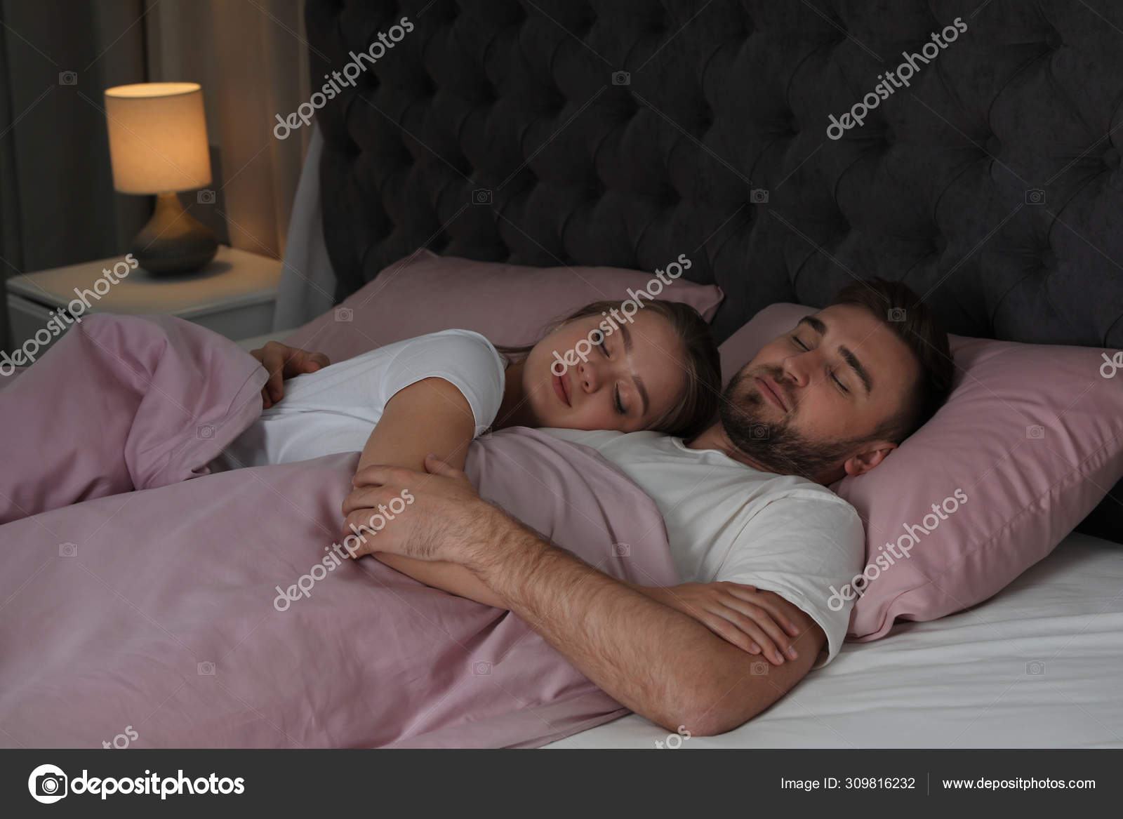 Young couple sleeping together in bed at nighttime — Stock Photo © NewAfrica #309816232