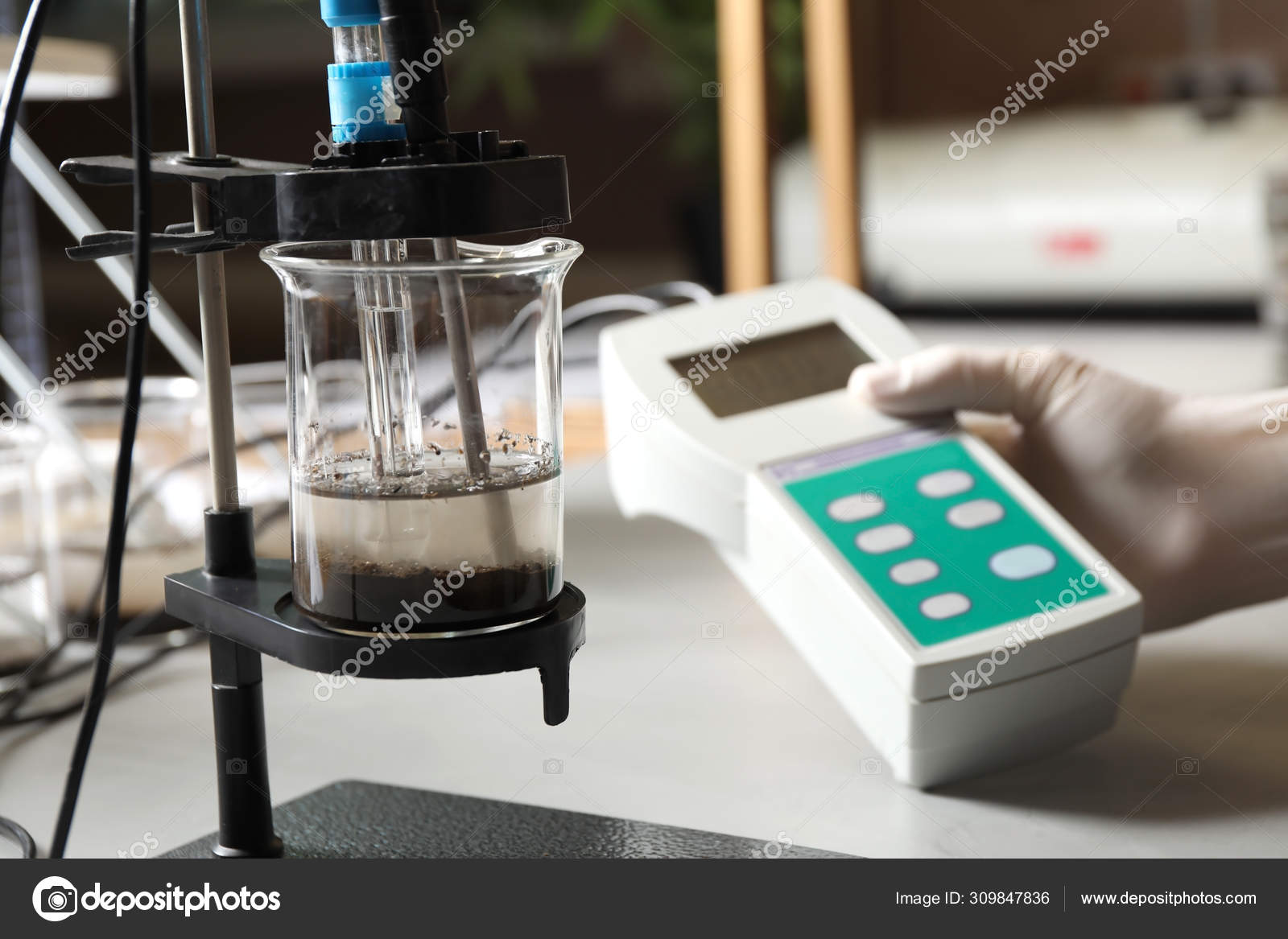 Scientist measuring acidity and pH of soil at table, closeup ...