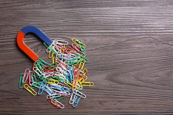 Magnet attracting paper clips on white background — Stock Photo ...