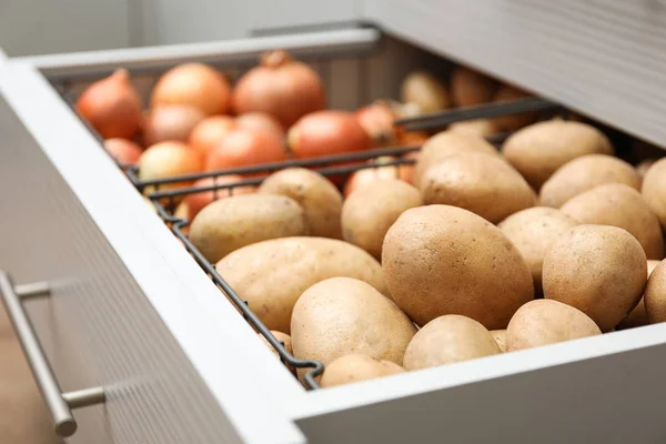 Open drawer with potatoes and onions, closeup. Orderly storage Stock ...