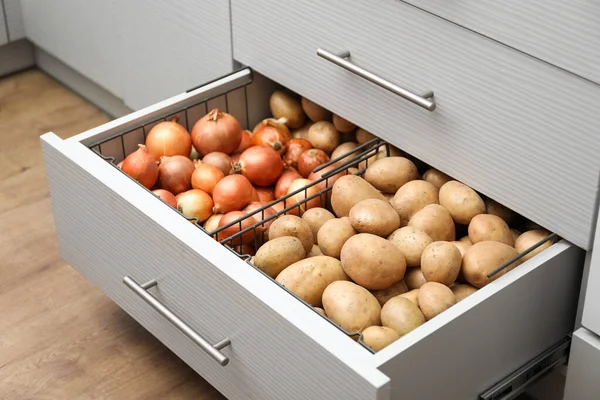 Open drawer with potatoes and onions, closeup. Orderly storage Stock ...