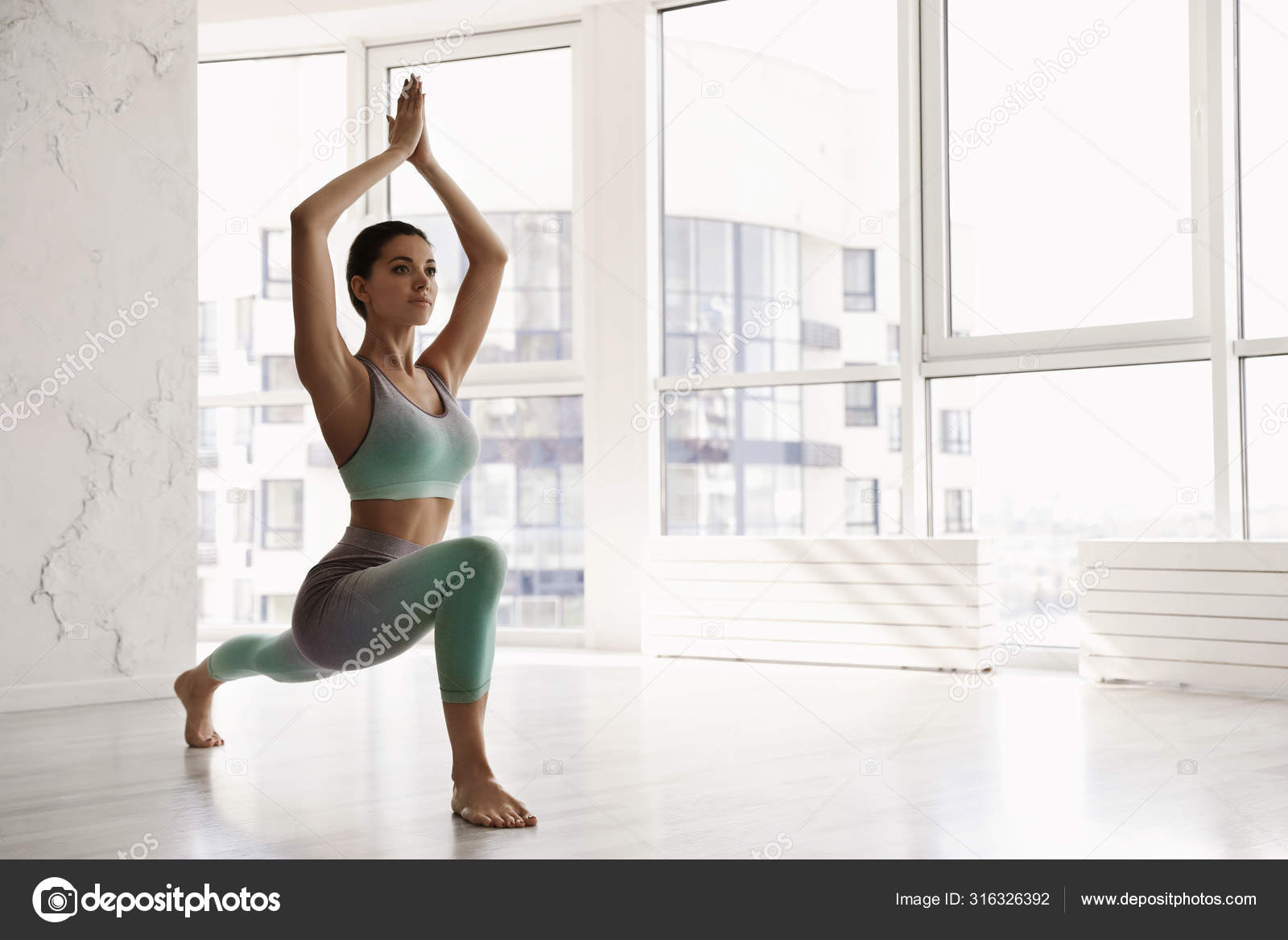 Young woman practicing crescent asana in yoga studio. High lunge pose ...