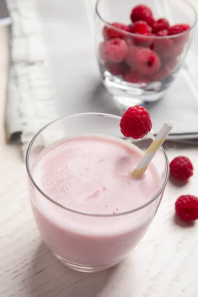 Tasty fresh milk shake with raspberry on white table, closeup - Stock ...