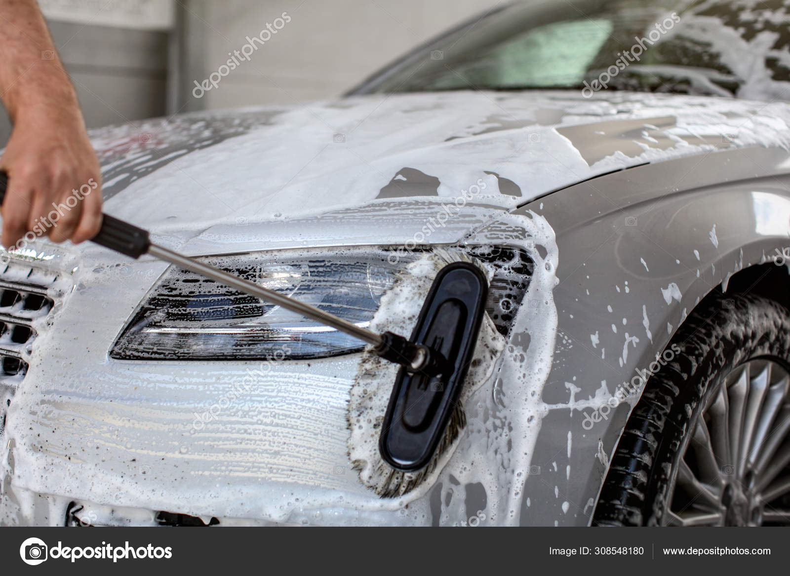 Front light of silver car washed in self serve carwash, man hand Stock ...