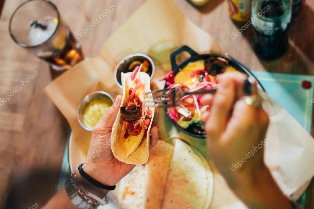 Mujer joven preparando y comiendo comida mexicana en un restaurante ...