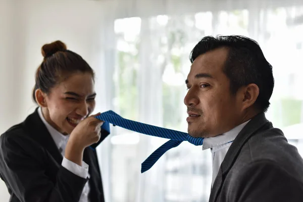 Conflict in the workplace Female employees are pulling the tie of male ...