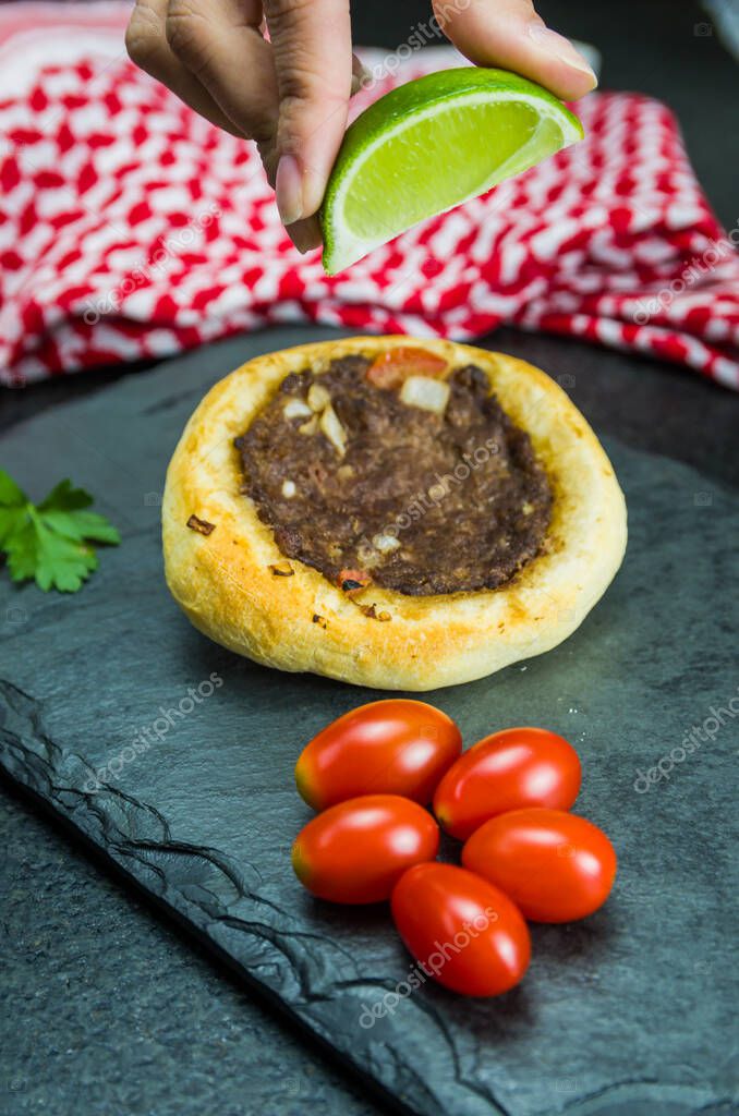 Deliciosa comida libanesa (árabe), exprimiendo limón en sfihas ...