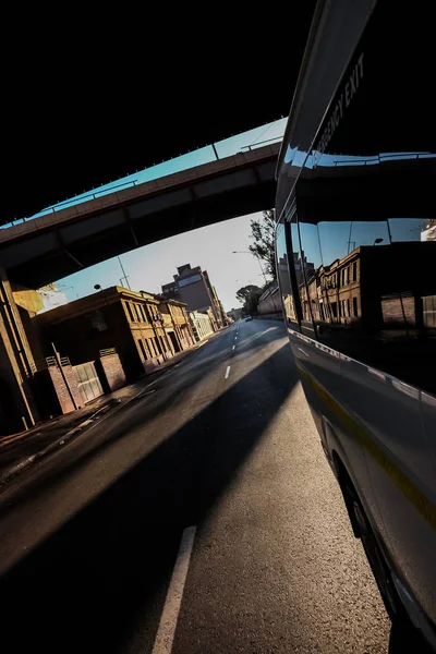 Looking back street view in a quiet city from a mini bus taxi window ...