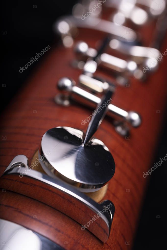 Una parte de un fagot con llaves plateadas sobre un fondo negro 2025